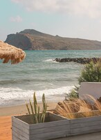 Na praia, espreguiçadeiras, guarda-sóis, toalhas de praia 