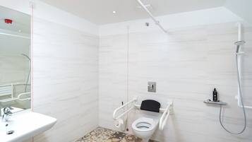 Um banheiro moderno com pia branca, vaso sanitário com assento preto e área de chuveiro.