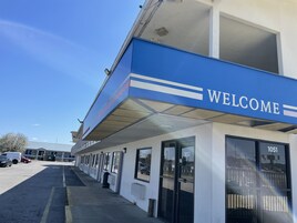 Um edifício com uma placa de 'WELCOME', número 1051, e uma galeria coberta.