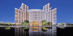 Um hotel moderno com fachada simétrica, vários andares e entrada central.