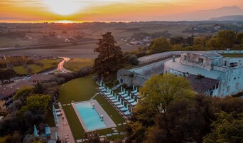 Um grande edifício histórico com piscina e área de descanso.