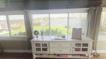 Quarto com um armário branco próximo a uma janela ampla com vista para um lago.