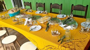 Uma mesa posta para refeição, com diversos pratos, copos e talheres.