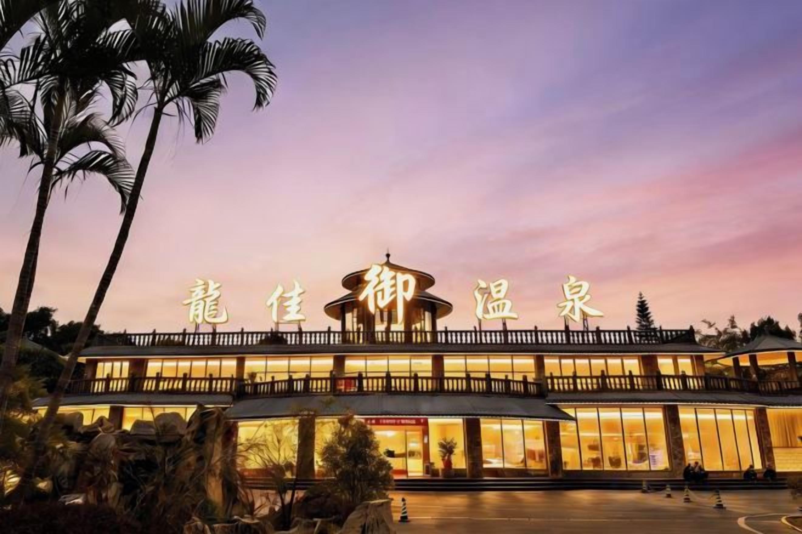 Um hotel com arquitetura tradicional, apresentando uma entrada imponente com letreiros iluminados.