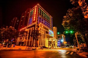 Um edifício bem iluminado com vários andares e uma entrada destacada.