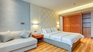 Quarto moderno com cama, sofá e guarda-roupa.