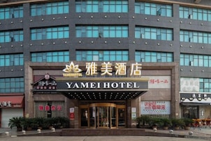 Um hotel com entrada imponente, vários andares e uma placa indicando ser o Yamei Hotel.