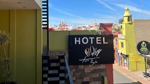 Placa de hotel com vista para um horizonte urbano ao fundo.