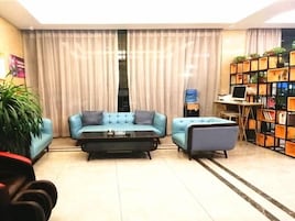 Uma sala de estar com sofá, mesa de centro e estante de livros.