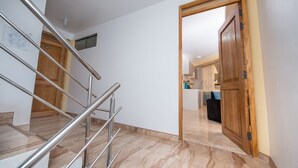 Um interior moderno com escadaria de mármore, portas de madeira e design limpo e minimalista.