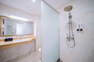 Casa de banho moderna com um espelho grande, uma pia e um chuveiro.