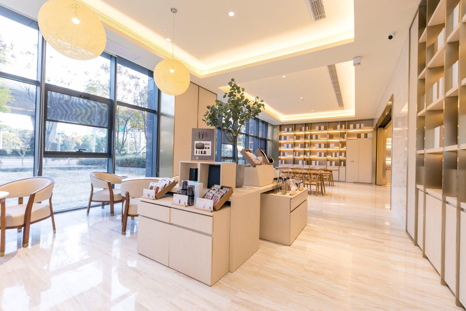 Um interior moderno com balcão de recepção, área de estar e estantes de livros.
