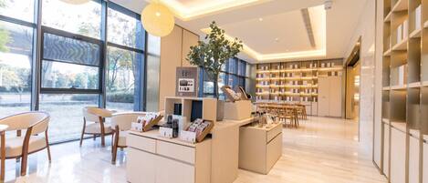 Um interior moderno com balcão de recepção, área de estar e estantes de livros.