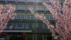 Um edifício com uma placa que diz 'JINJIANG INN'.