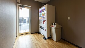 Um corredor com uma máquina de vendas automática e um contentor de lixo.