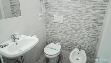 Quarto Individual Standard | Casa de banho | Um polibã, um secador de cabelo, um bidé, toalhas fornecidas