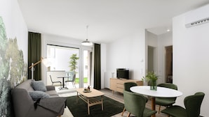Uma sala de estar moderna com sofá, mesa de centro e área de jantar com cadeiras e mesa.