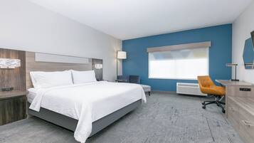 Quarto de hotel moderno com uma cama grande, uma escrivaninha, uma cadeira e uma janela.