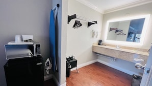 Uma casa de banho com micro-ondas, secador de cabelo e porta-toalhas.