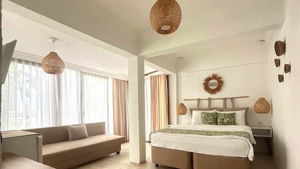 Quarto moderno com uma cama grande, um sofá e uma escrivaninha.