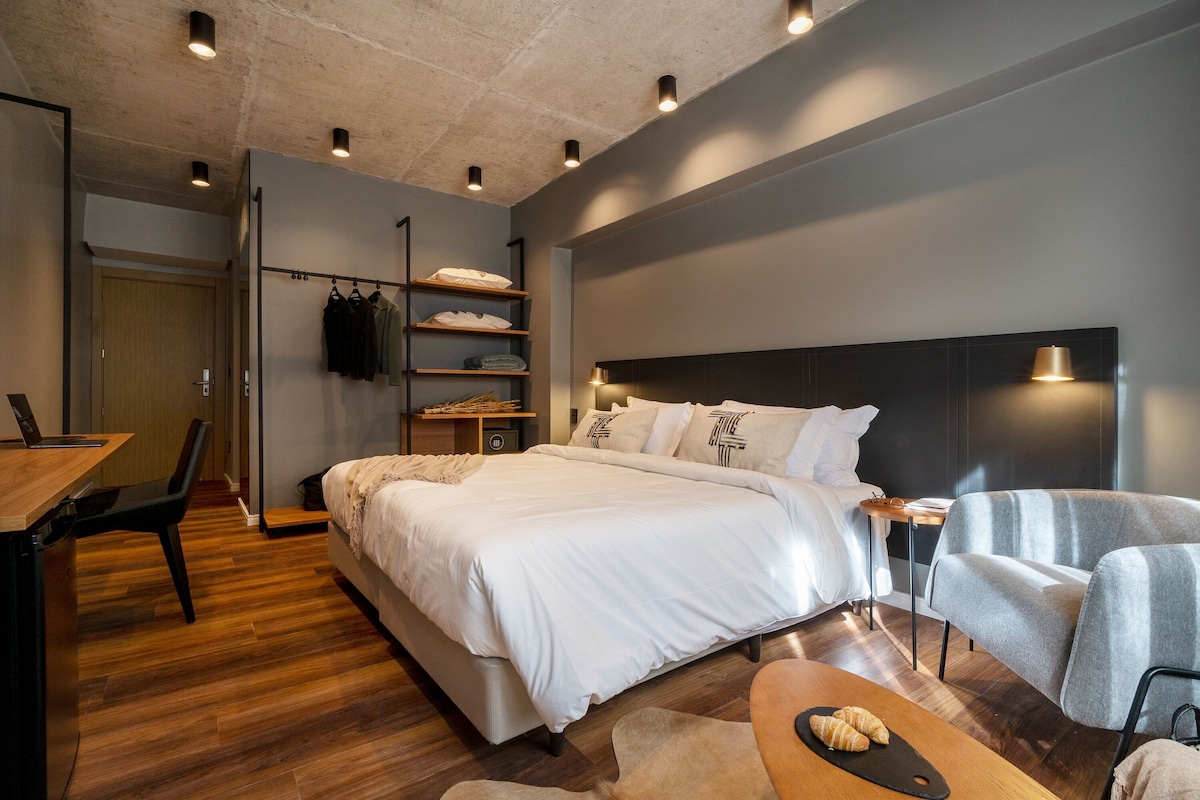 Quarto moderno com uma cama grande, uma escrivaninha e uma cadeira.