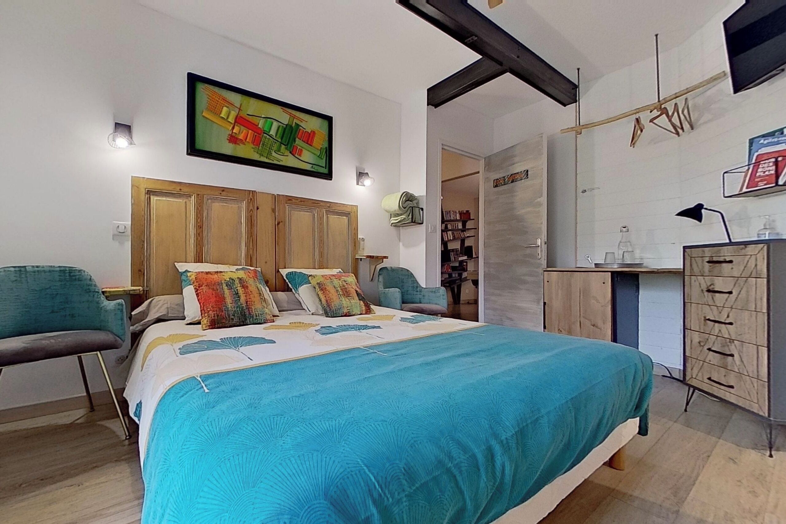 Quarto com uma cama, uma escrivaninha e uma cadeira.