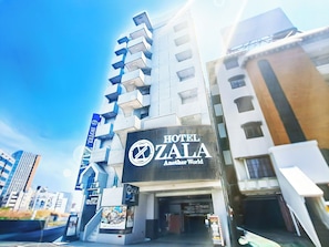 Um edifício moderno de hotel com uma placa de destaque que diz "HOTEL ZALA Another World".