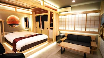 Quarto de hotel com uma cama, um sofá, uma mesinha, um espelho e ar-condicionado fixado na parede.