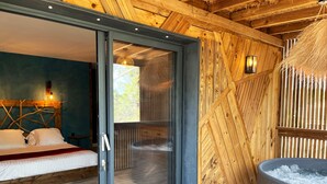 Quarto com porta de vidro deslizante para uma varanda, teto de madeira e hidromassagem.