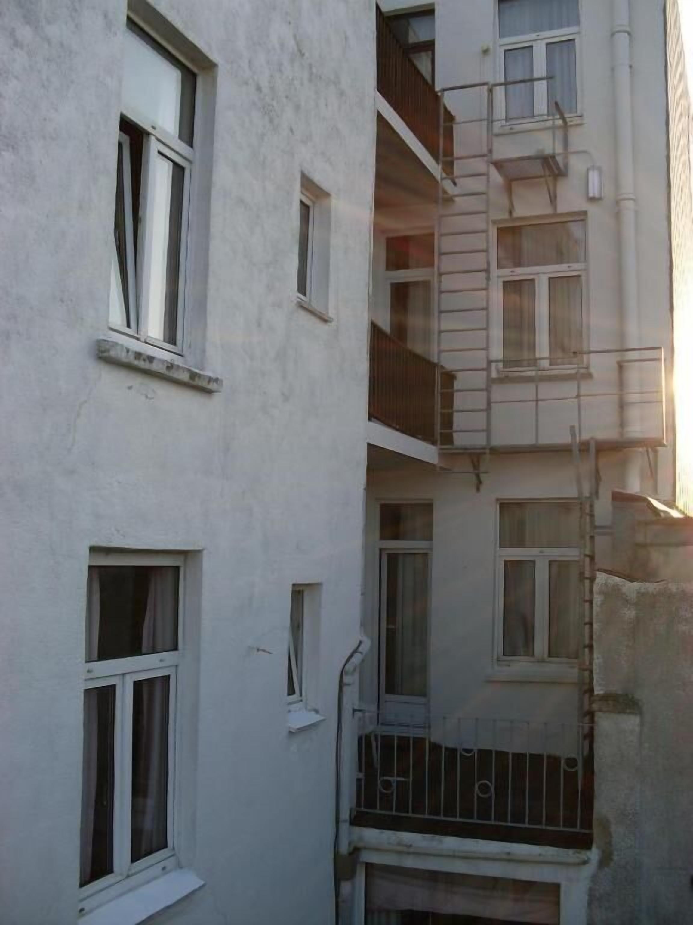 Um edifício com vários andares, janelas e varandas.