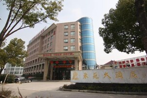 Um hotel com entrada destacada, grande placa e fachada de edifício moderna.