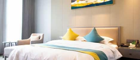 Quarto de hotel com cama, uma cadeira, mesa de cabeceira e um quadro na parede.