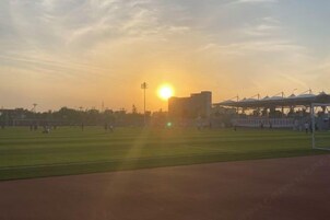 Um estádio com vista desobstruída para o campo e áreas de assentos ao pôr do sol.