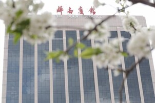 Um edifício moderno de hotel com uma placa que diz "Fujian Hotel" em letras vermelhas.