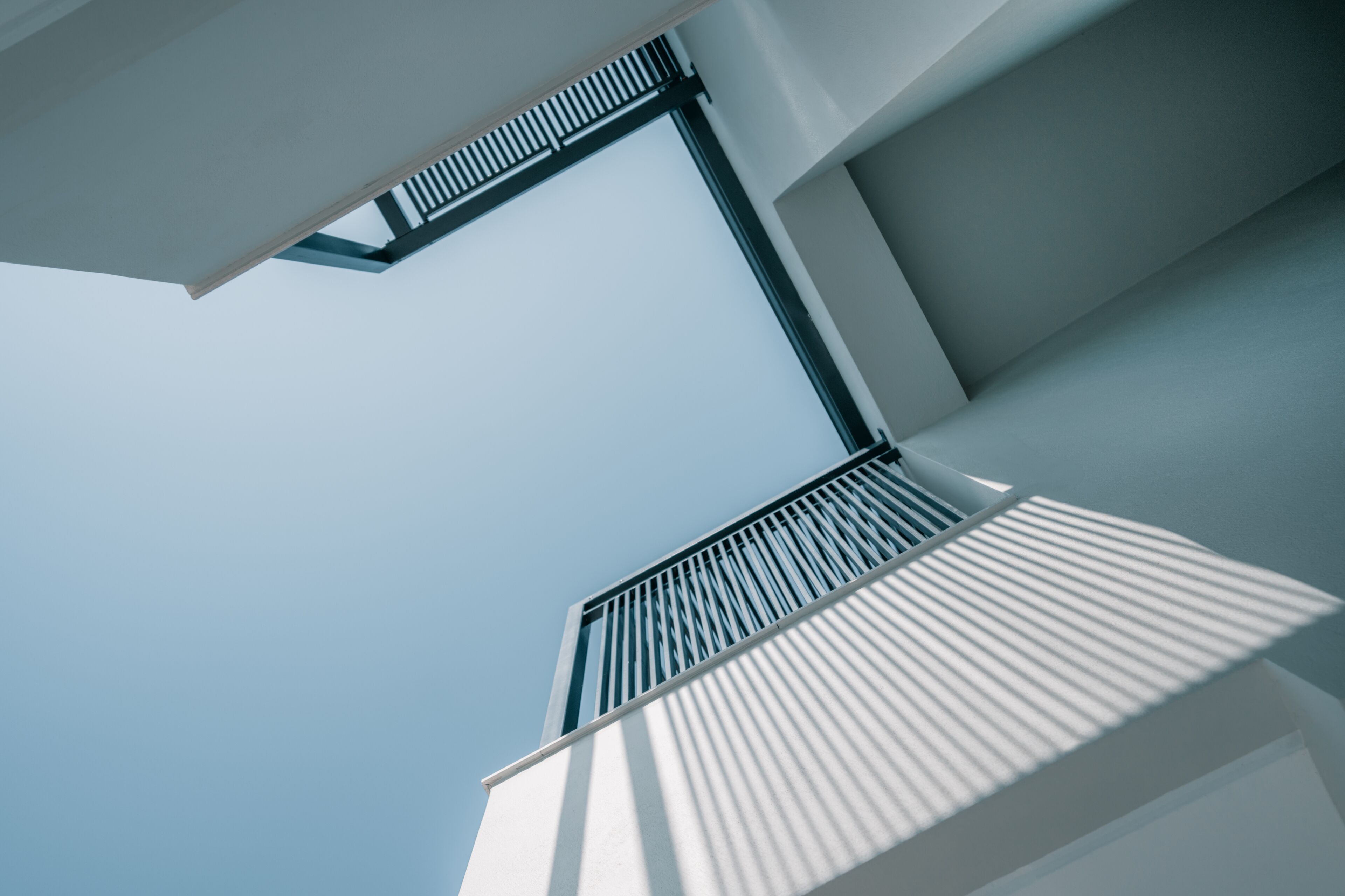 Estrutura arquitetônica moderna com design geométrico, destacando uma saliência e um guarda-corpo de metal.