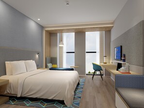 Quarto de hotel moderno com cama, escrivaninha, cadeira e televisão.