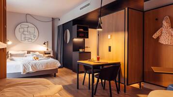 Quarto moderno com cama, mesa de cabeceira, luminária e uma obra de arte circular pendurada na parede.