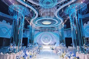 Um espaço com palco central, diversas áreas de estar e luminárias decorativas.