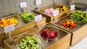 Buffet com diversas opções de comida, incluindo saladas, frutas e legumes.