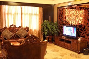 Uma sala de estar tradicional com sofá, televisão e painéis decorativos.