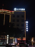 Edifício de hotel com letreiros iluminados e uma bandeira no topo.