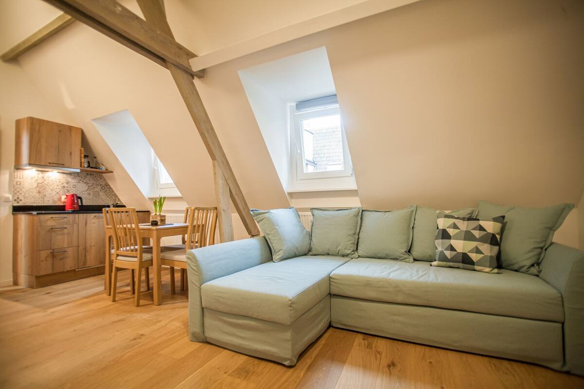 Um apartamento loft acolhedor, com área de refeições, sofá e cozinha.