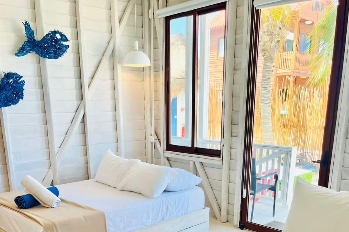 Um quarto acolhedor com uma cama, uma mesinha e uma janela com vista para o exterior.