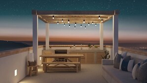 Um pátio externo com pérgola, mesa de madeira, sofá e televisão.