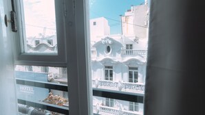 Um hotel com varandas, uma placa indicando 36 acomodações e vista para a cidade.