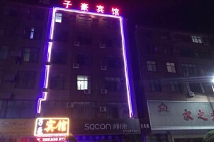 Um edifício com letreiros iluminados, várias janelas e uma entrada visível.