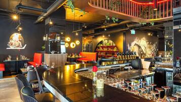 Uma área de bar moderna com balcão central, assentos e escada.