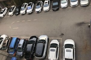 Um estacionamento com várias fileiras de carros estacionados.