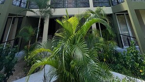 Um edifício com vários andares, varandas, janelas amplas e céu claro.