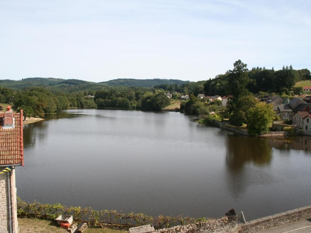 Um lago tranquilo rodeado por casas e vegetação.
